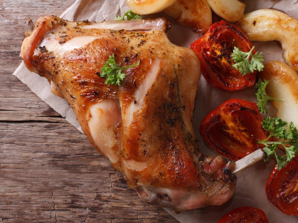 Conejo joven frito con manzanas y tomates.